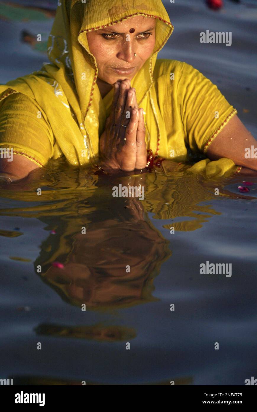 An Indian women takes a dip at Sangam, the confluence of the Ganges and ...