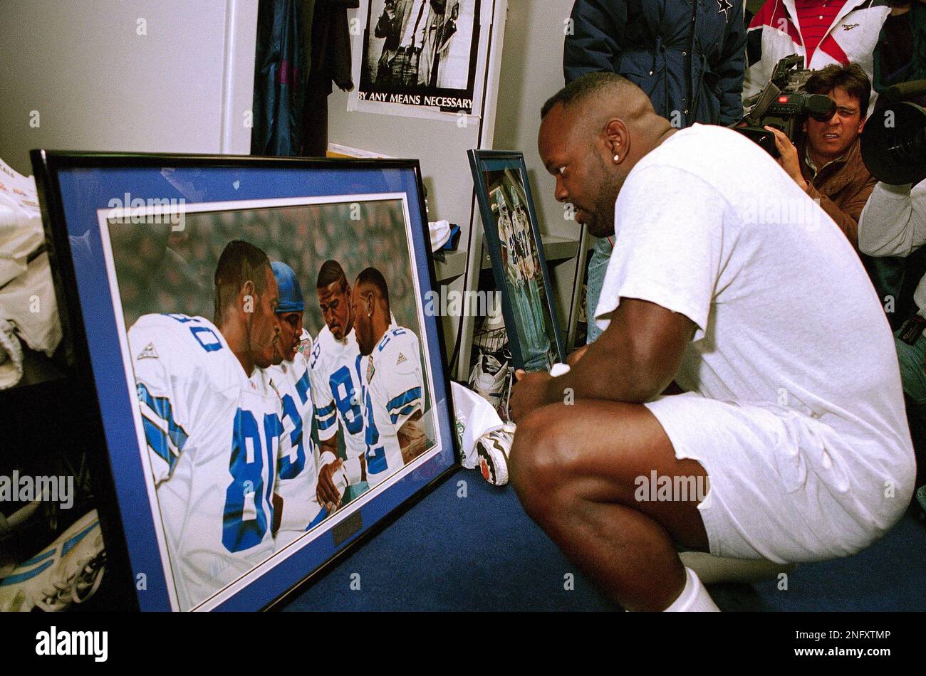 Dallas Cowboy running back Emmitt Smith looks at a painting showing several players including ...