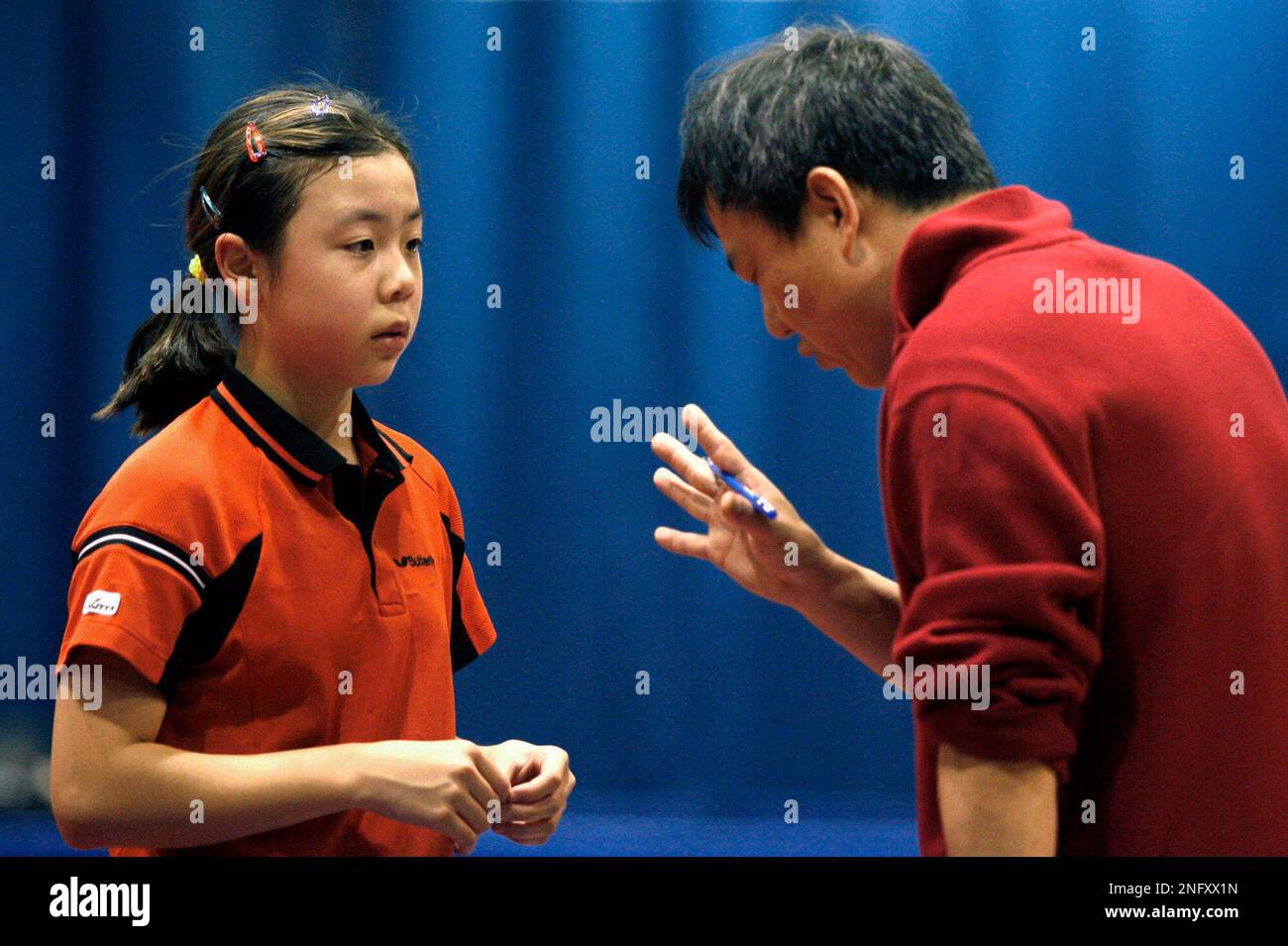 Twelve-year-old Ariel Hsing gets instruction from her coach and father ...