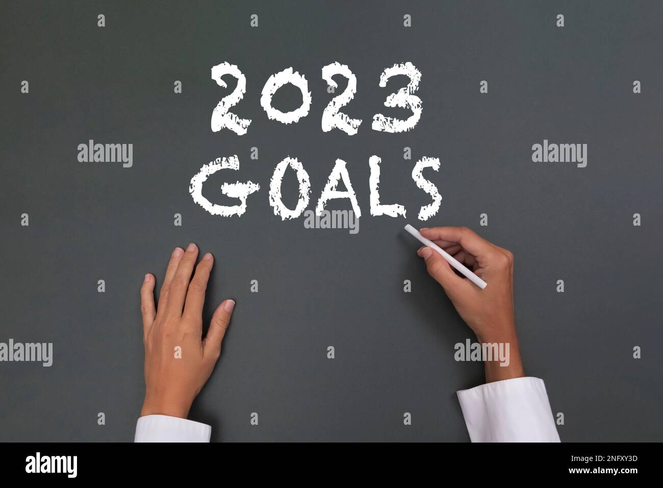 A person writing "2023 goals" on a dark blackboard Stock Photo - Alamy