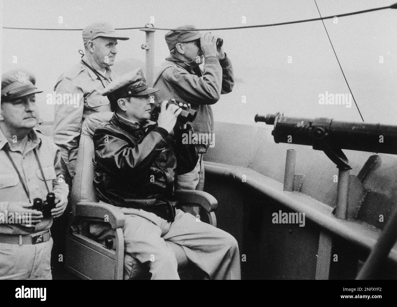 Gen. Douglas MacArthur, seated, and members of his staff view pre ...