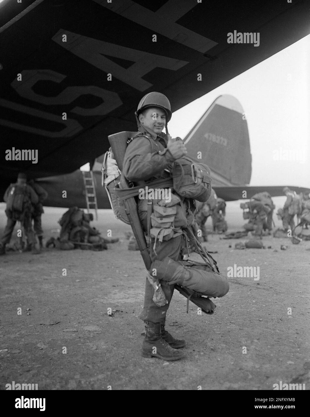 Paratrooper Pfc. Leonard Allore of Michigan is loaded down with gear as ...