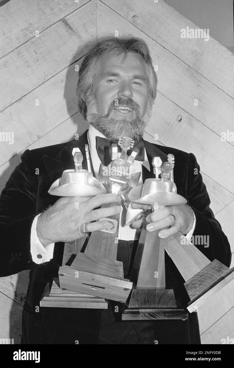 Country western singer Kenny Rogers holds the four awards he won for ...