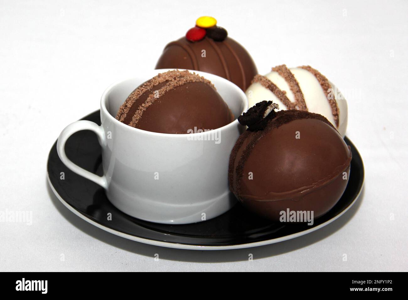 Chocolate bombs in mug with hot milk, filled with marshmallows and ...