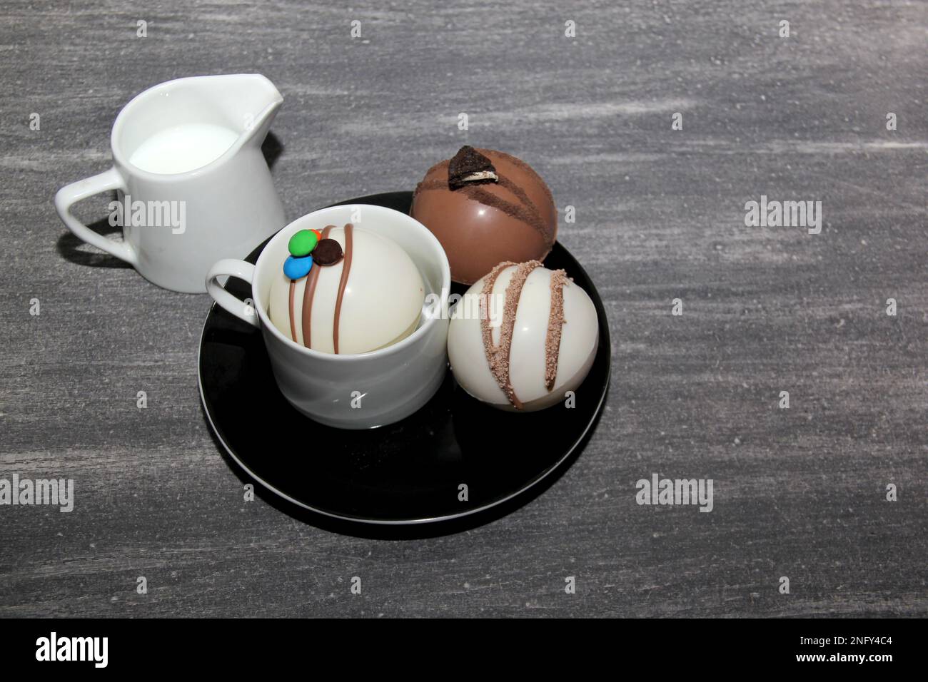 Chocolate bombs in mug with hot milk, filled with marshmallows and ...