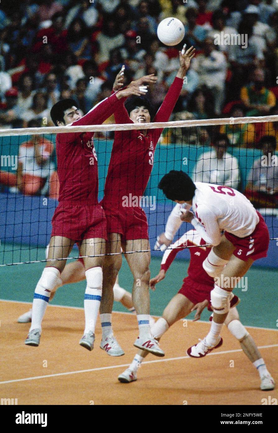 China's Liqun Yang, left, and Juemin Yu, center, jump to block the shot ...