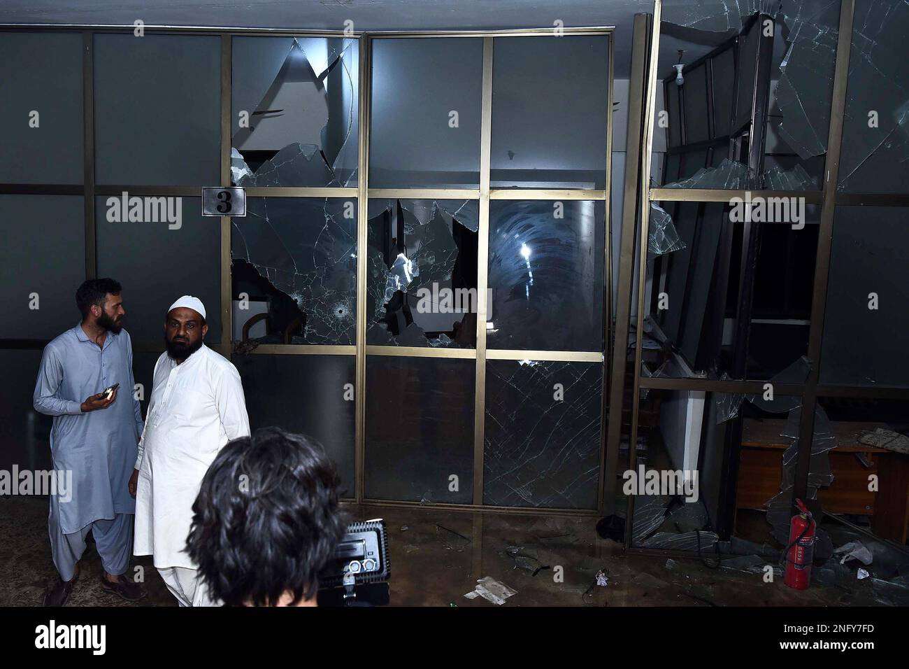 Plainclothes police officer examine a damage area after security forces ...