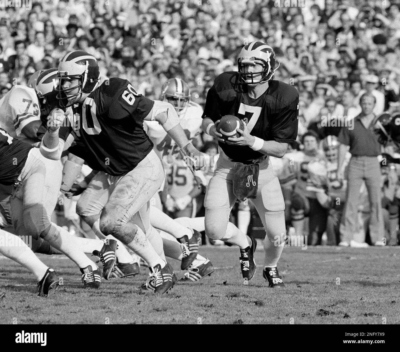 Michigan Wolverine quarterback Rick Leach (7) scrambles out of the ...
