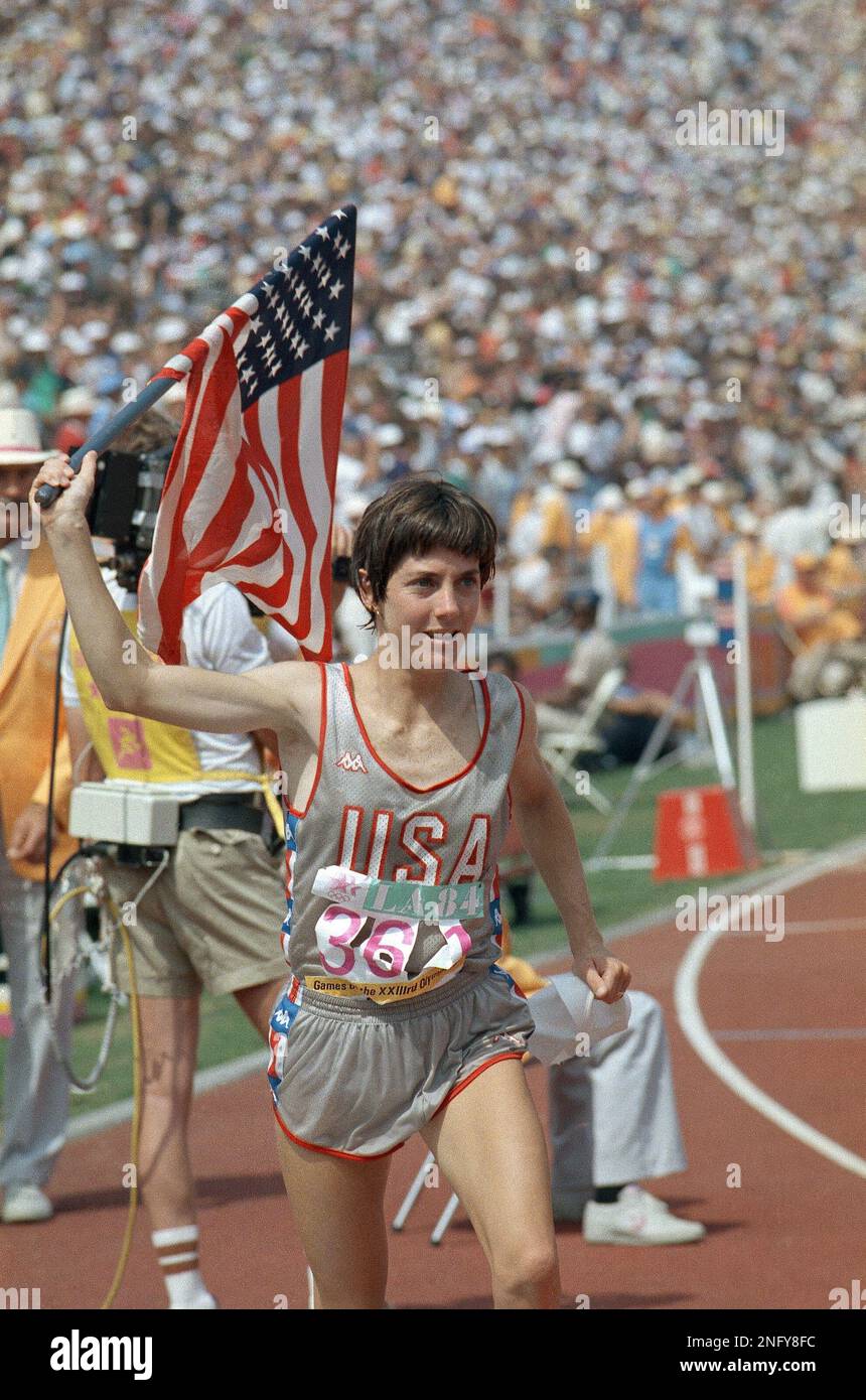 U.S. runner Joan Benoit of Freeport, Maine, waves the American flag on ...