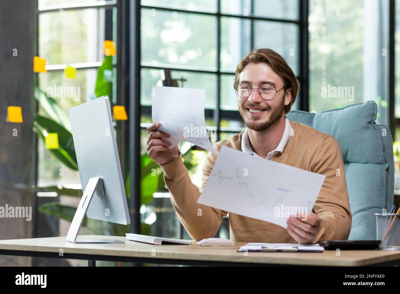 A young man, a businessman, a programmer sits in the office at a ...