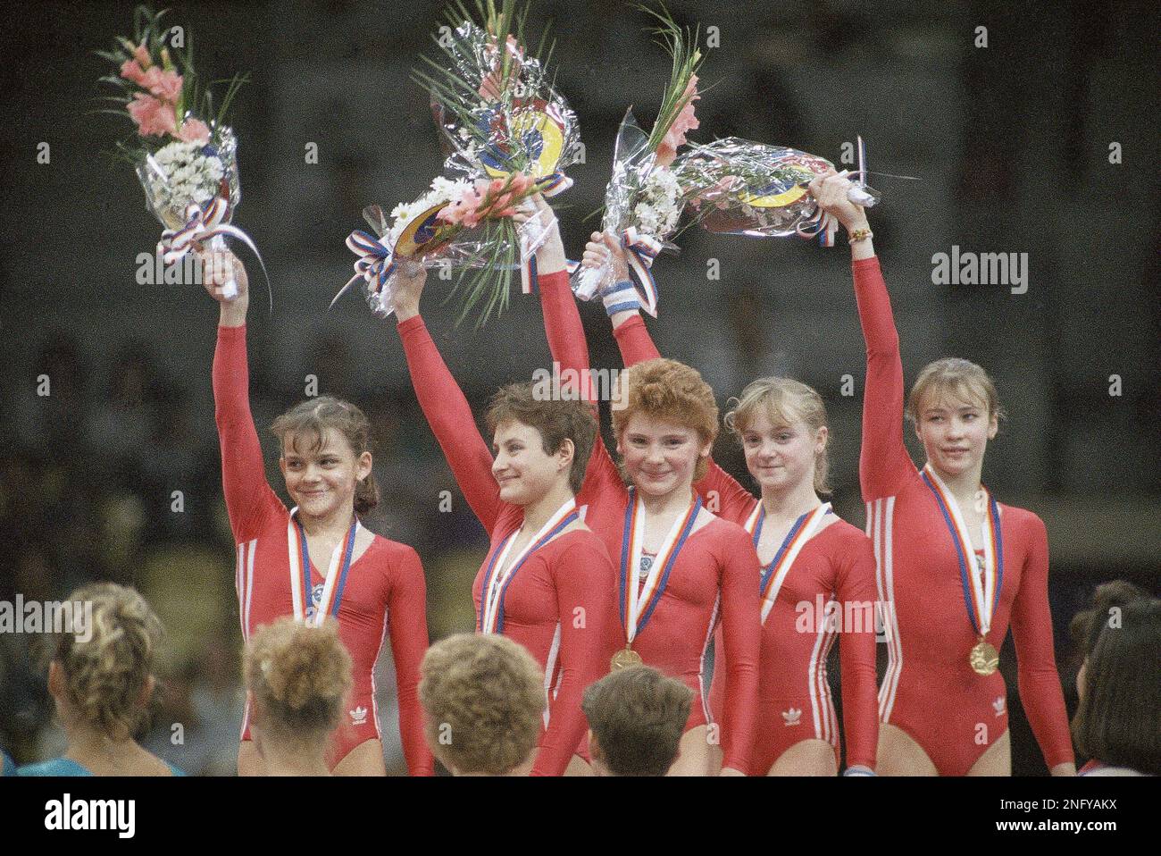Soviet gymnasts wave flowers after receiving gold medals in the women's ...