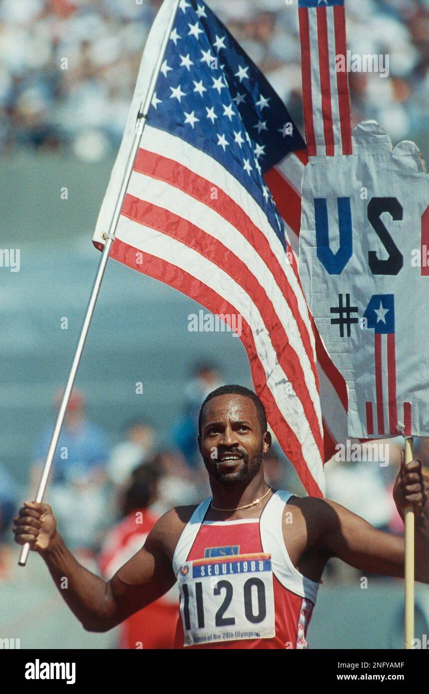 Andre Phillips of the USA waves the Stars and Stripes and a sign ...