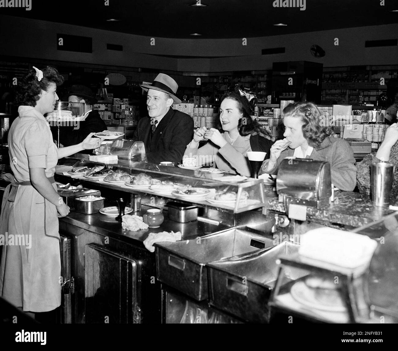 A waitress, left, serves customers at the coffee shop section in the ...