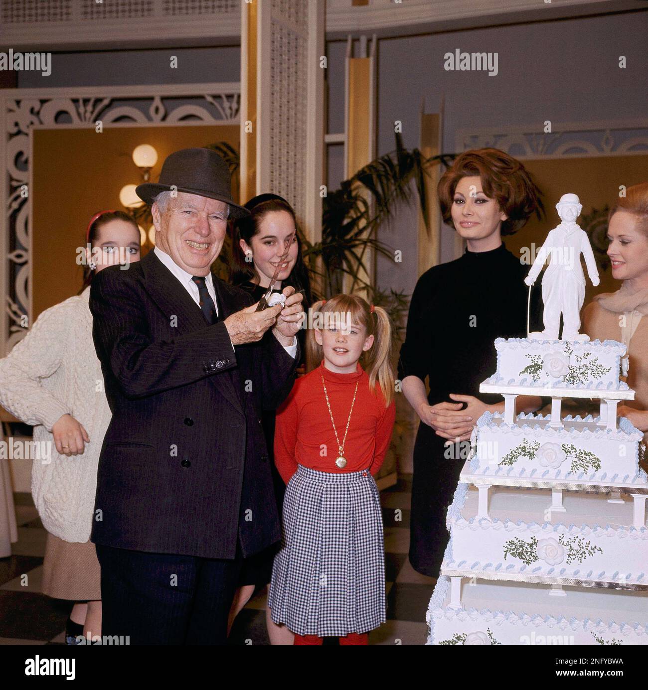 Veteran actor Charlie Chaplin poses near birthday cake on his 77th ...