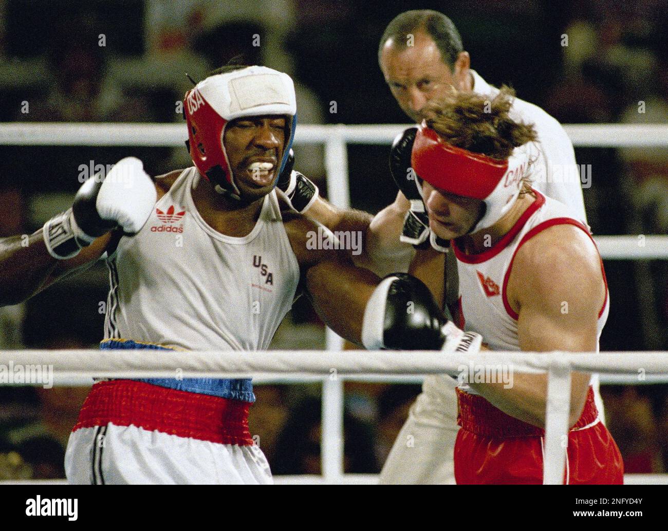 Henry Tillman takes a right to the head as he scores with a left to ...