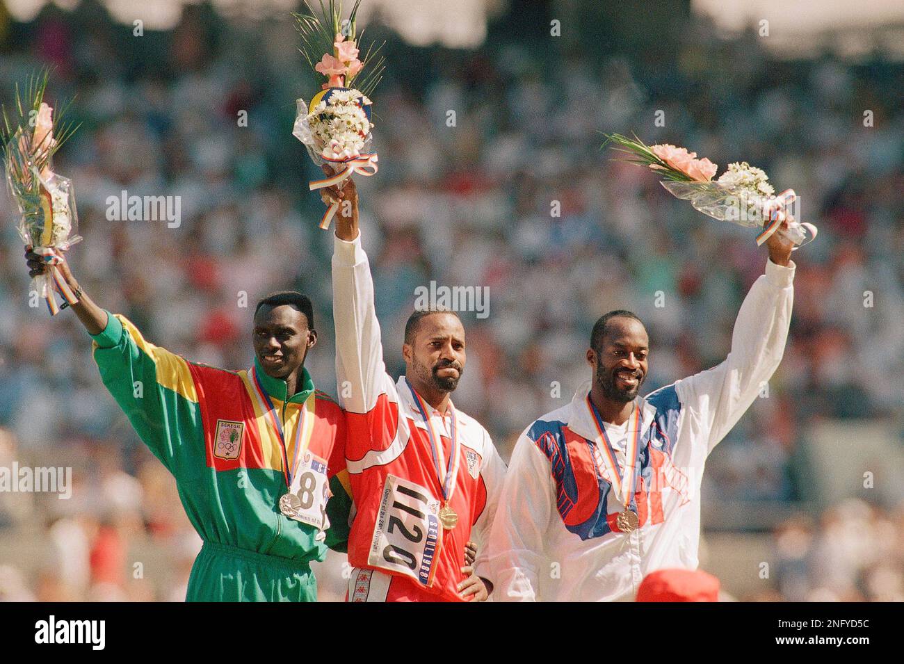 Andre Phillips of Milwaukee, Wis., center, stands on the medals podium ...