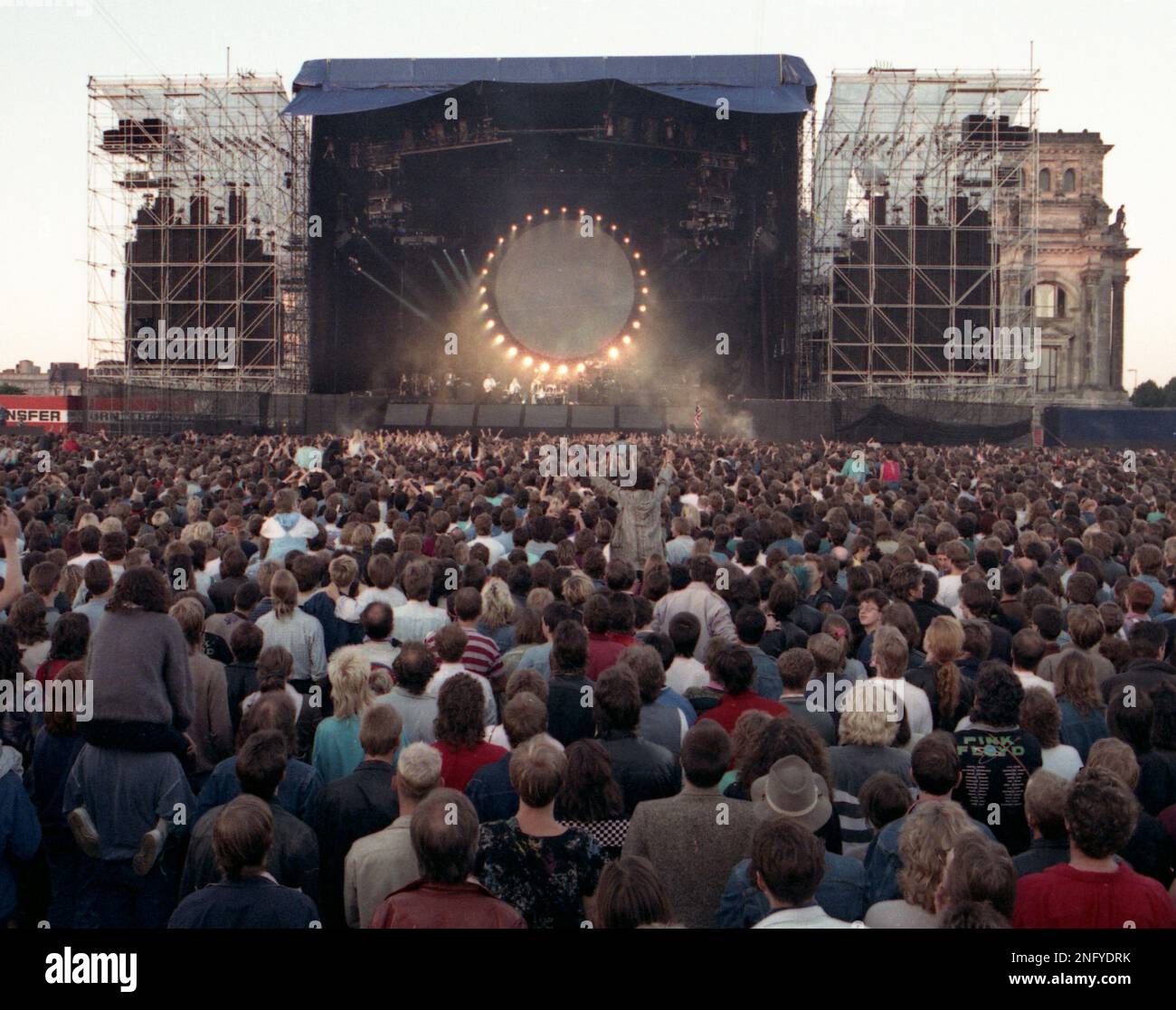 Cheering fans are crowd the front of the stage as British rock band ...