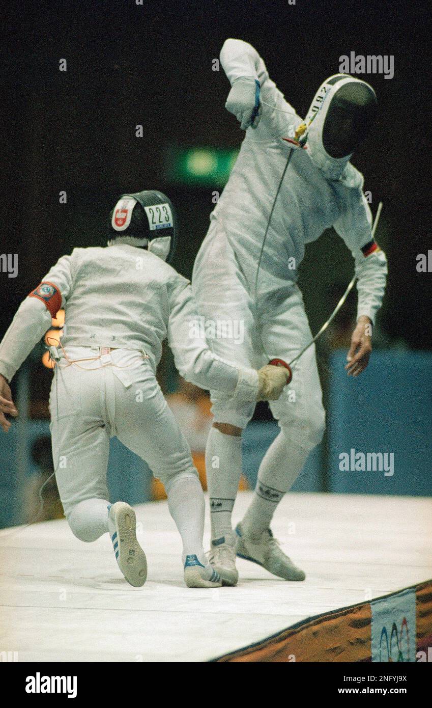 Matthis Behr of West Germany, right, lets go of his foil as he fences ...