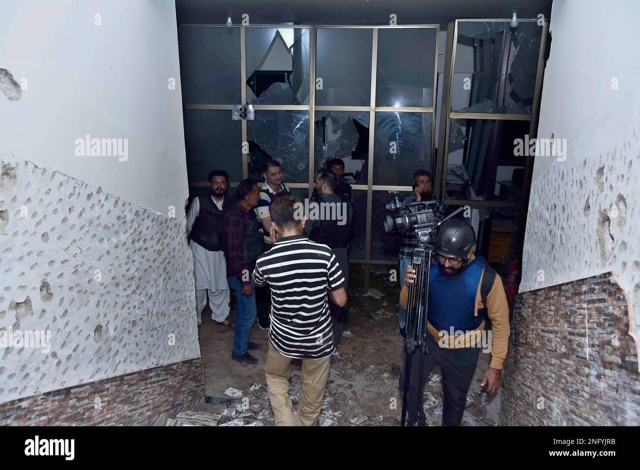 Plainclothes police officers examine a damage area after security ...