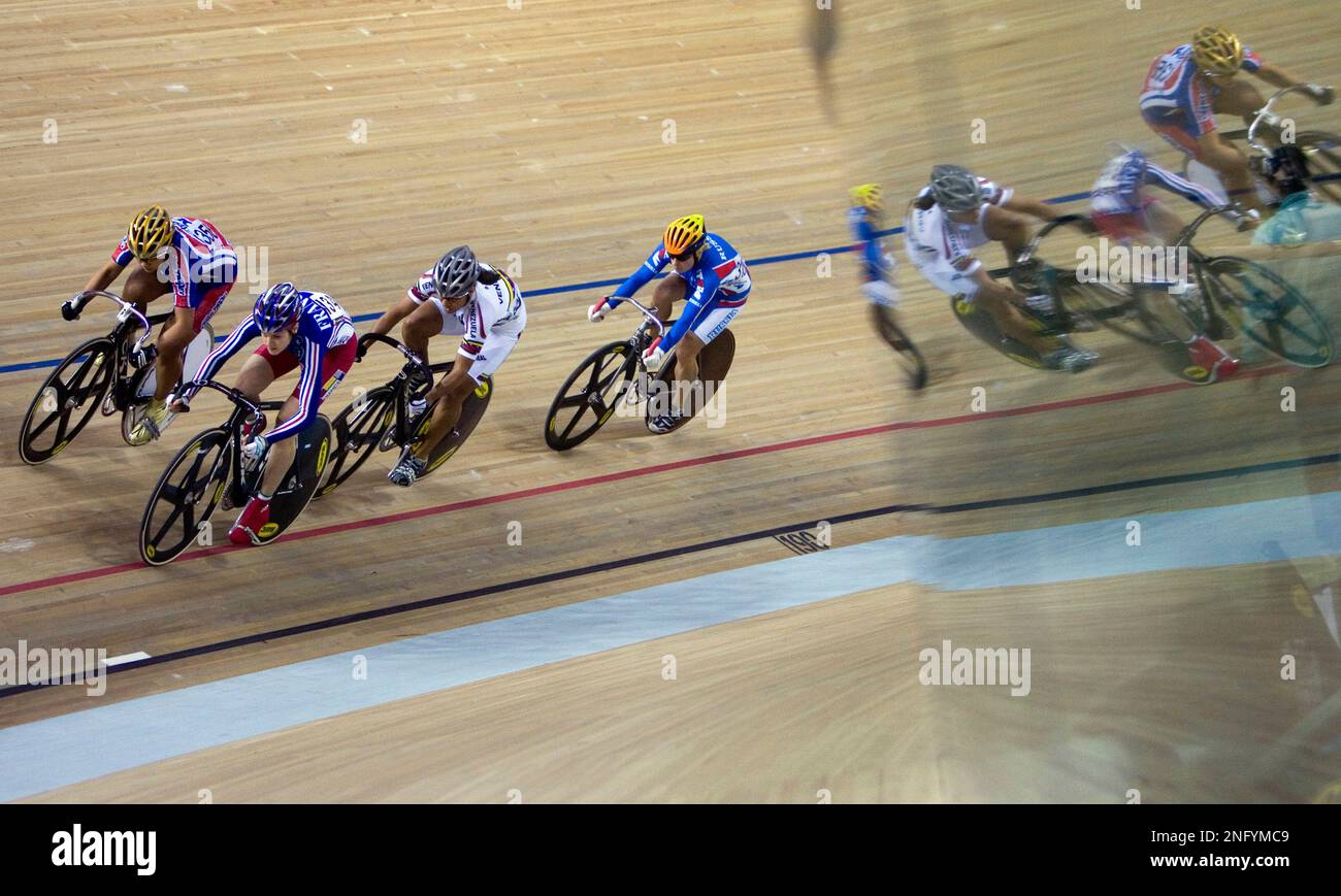 Cyclists is reflected on a glass as they competes in Women's Keirin ...