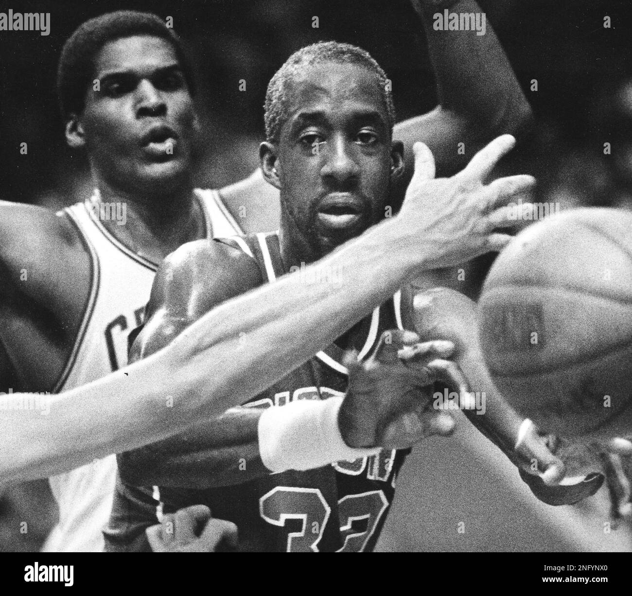 Detroit Pistons' Dan Roundfield, right, passes the ball despite the ...