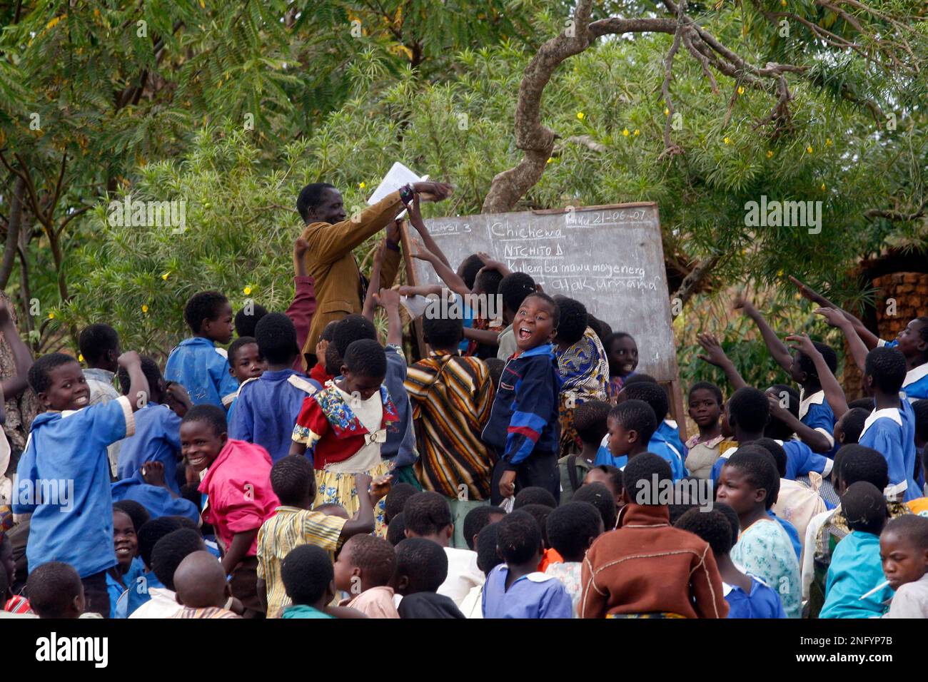 Malawi schoolchildren listen to the teacher from their outdoor ...