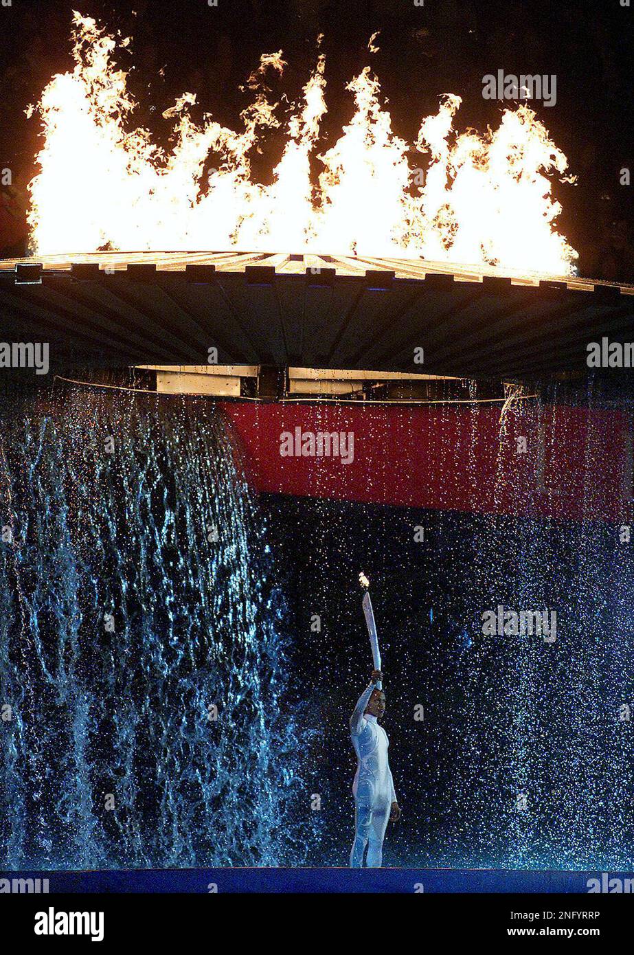 Australian runner Cathy Freeman stands under the Olympic torch after ...