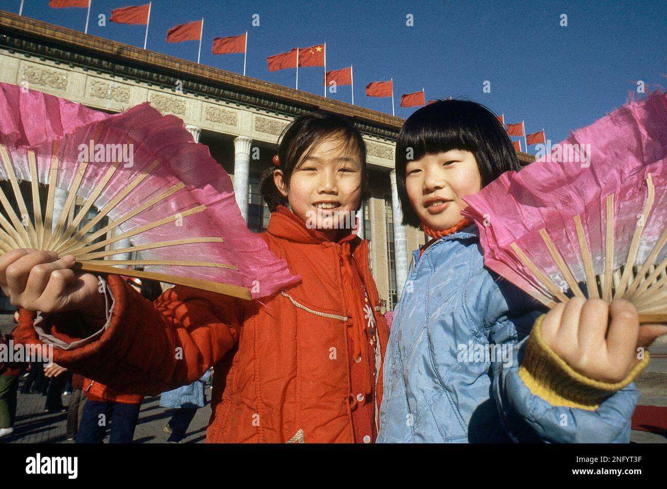 Chinese youngsters display fans they will use to greet a VIP during a ...