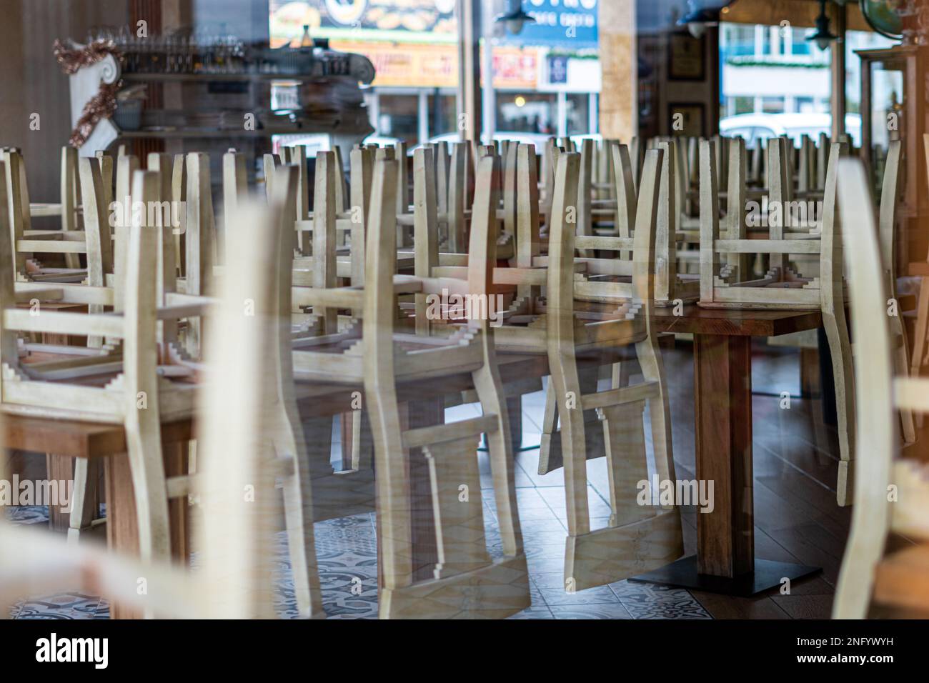An interior with chairs arranged upside-down on the tables Stock Photo ...
