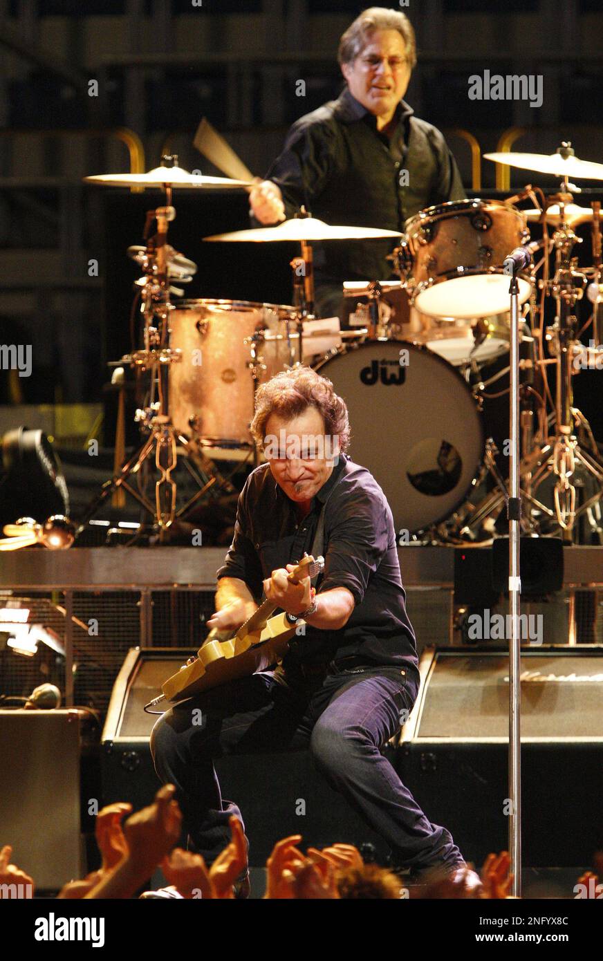 Bruce Springsteen, front and Max Weinberg on drums, back perform with ...