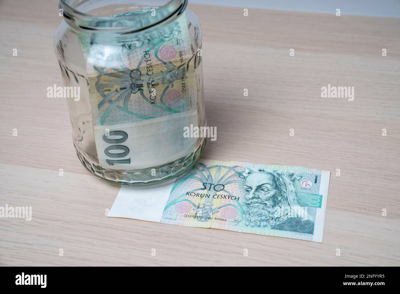 100 korun banknote of the Czech Republic banknotes in the glass jar ...