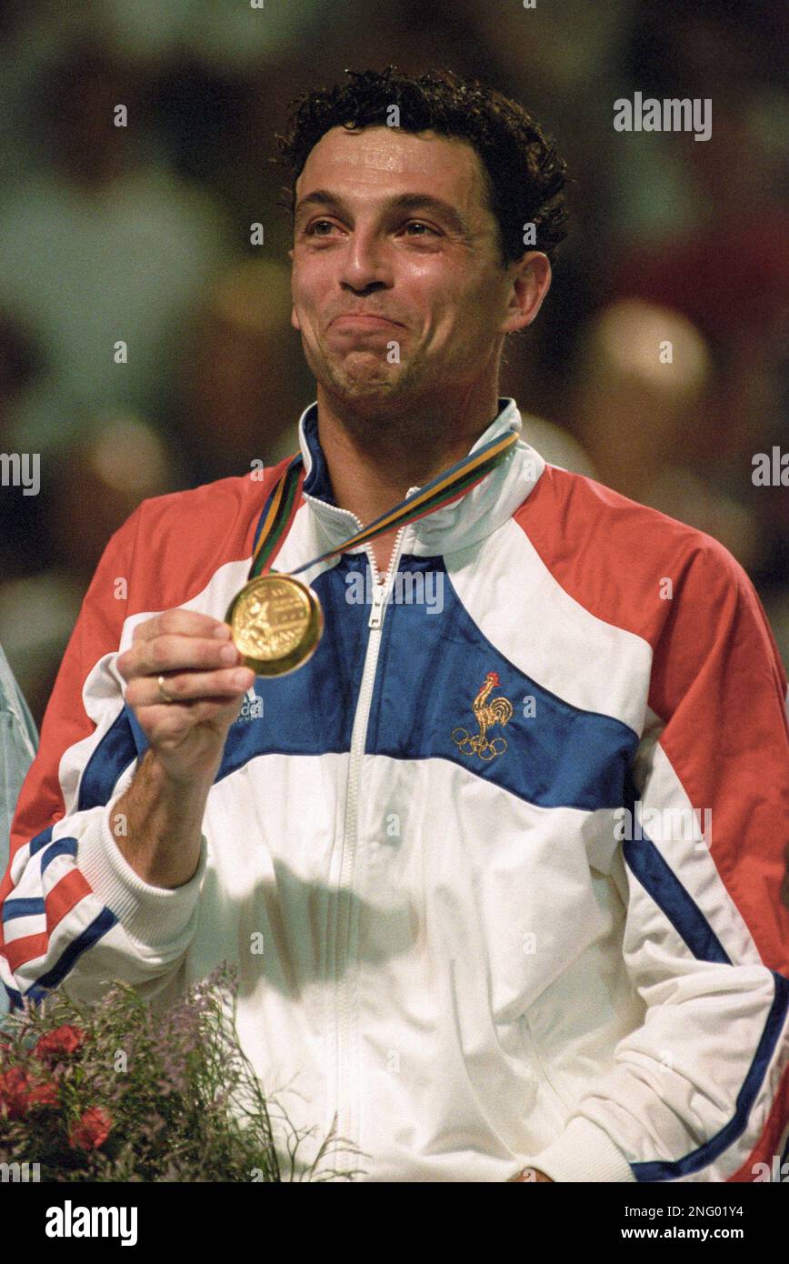 France's Philippe Omnes shows off his gold medal during the award ...