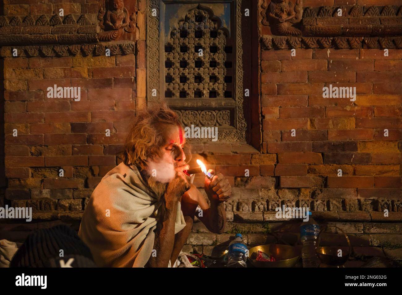 A Hindu holy man, or Sadhu, the follower of Lord Shiva, smokes ...