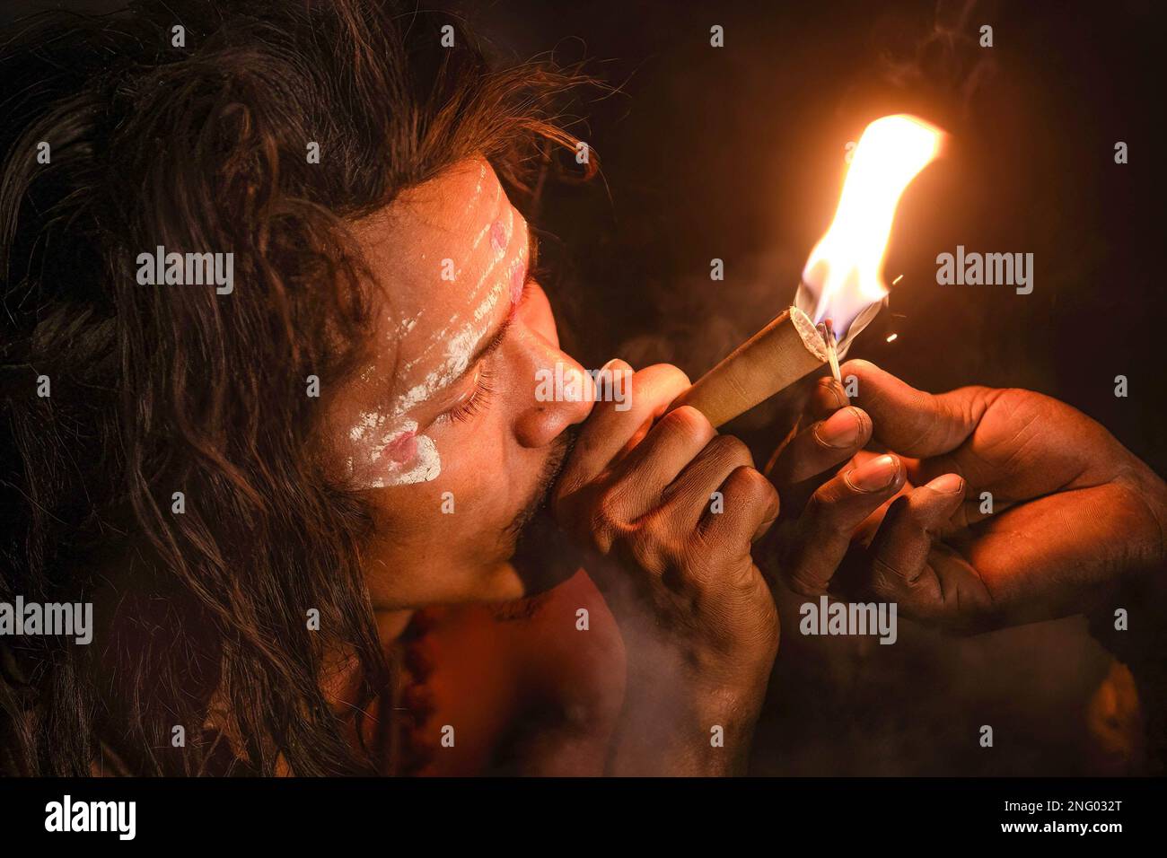 A Hindu holy man, or Sadhu, the follower of Lord Shiva, smokes ...