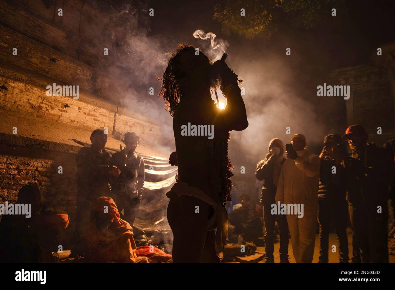 A Hindu holy man, or Sadhu, the follower of Lord Shiva, smokes ...