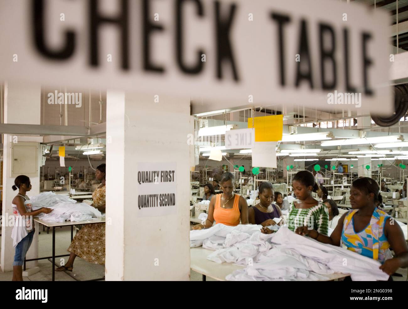 Workers check garments in the quality control area of the assembly line ...