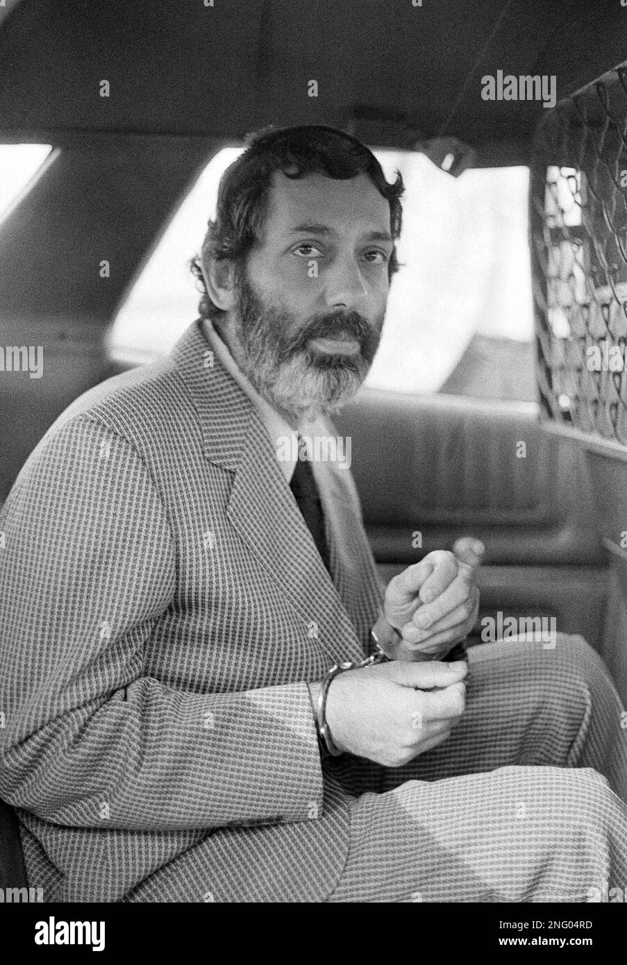 Joseph Kallinger of Philadelphia, his wrists handcuffed and sporting a ...