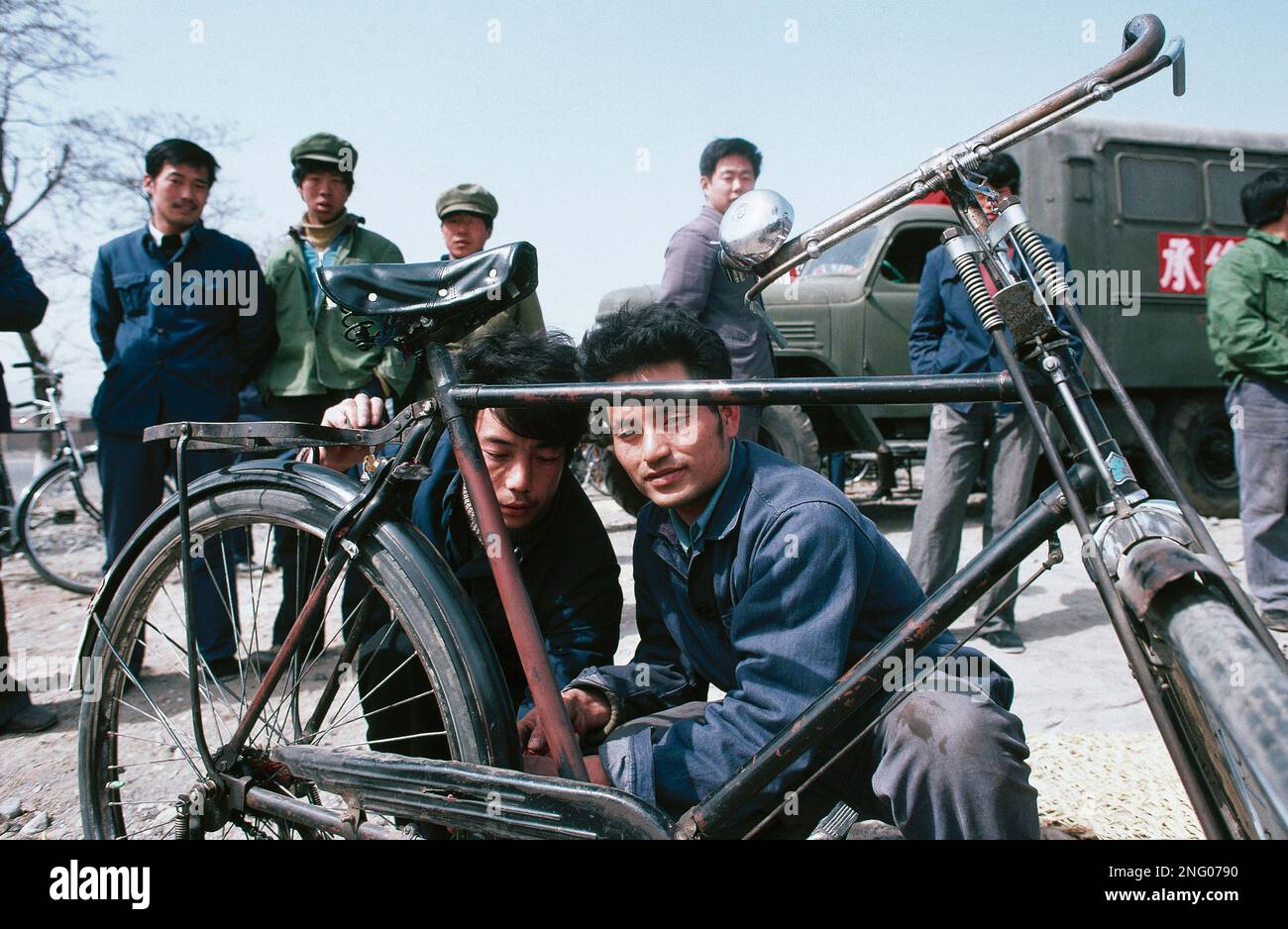 Seen here are unidentified men fixing a bicycle in Beijing, China in ...