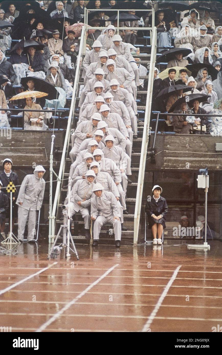 Dressed in rain gear, judges at the 1964 Summer Olympics in Tokyo ...