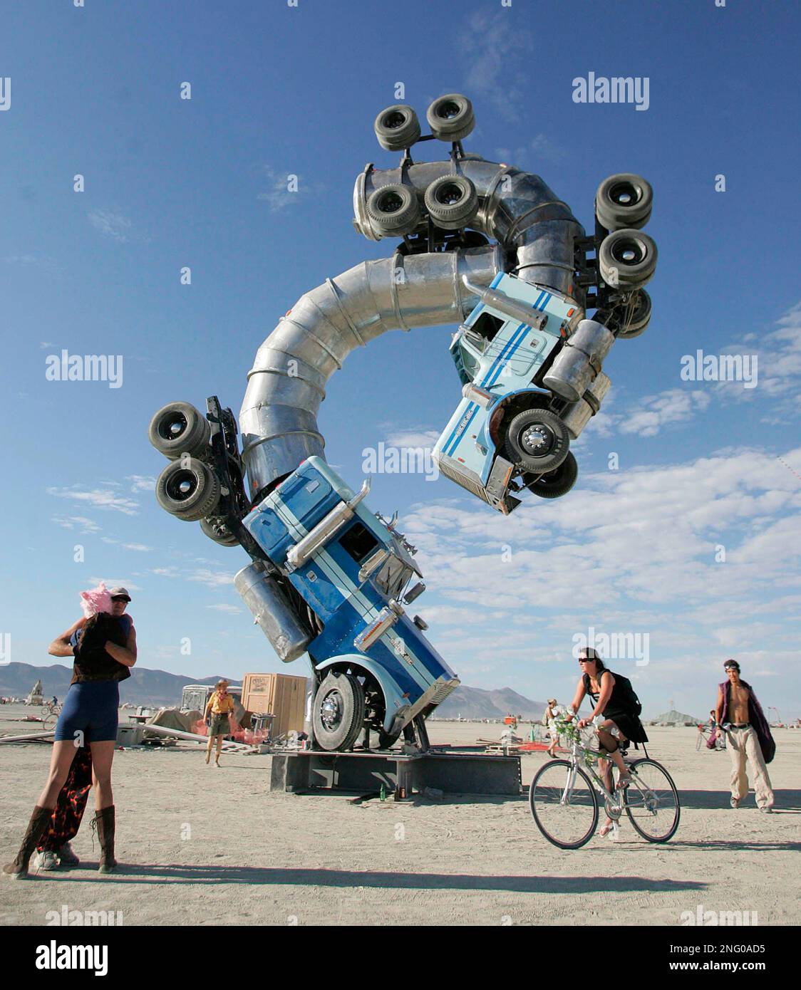 Burning Man festival participants enjoys the playa near an art ...