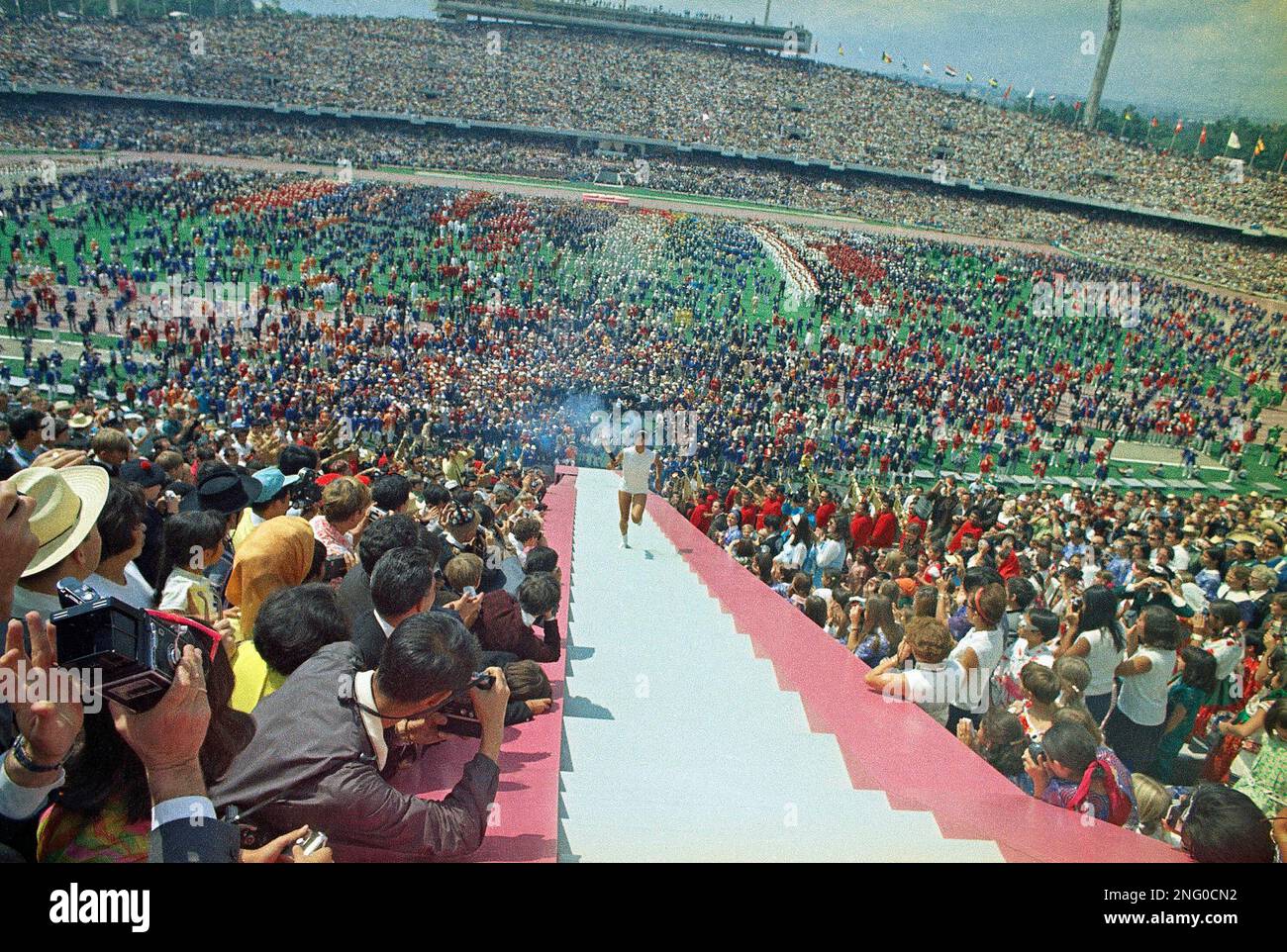 The Olympic torch is brought into Olympic stadium during opening day ...