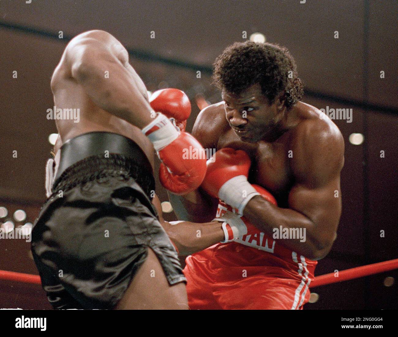 Mike Tyson, left, delivers a left uppercut to the stomach of Tony Tucker during early round ...