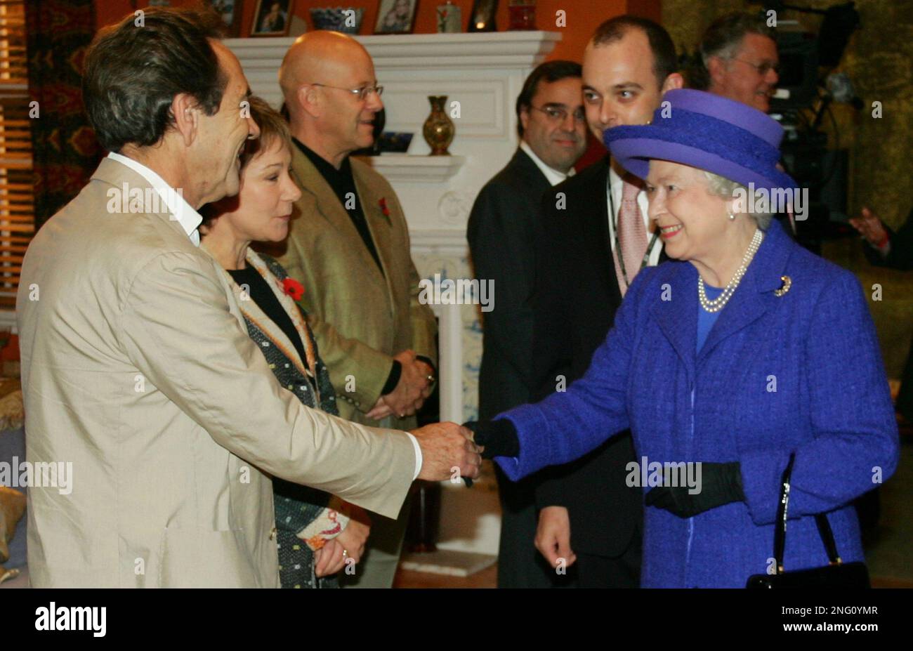 England's Queen Elizabeth II, right, shakes hands with actor Robert ...