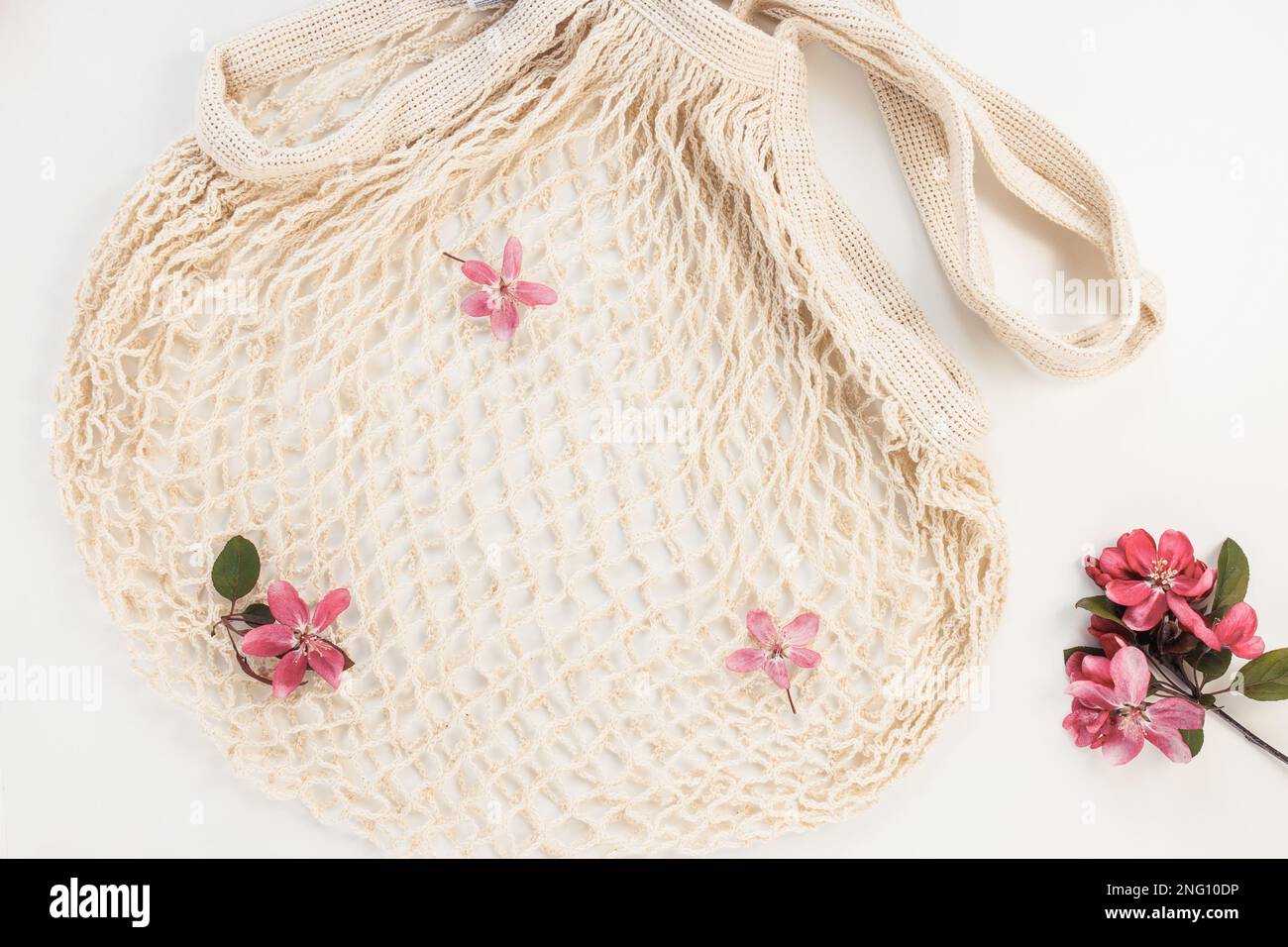 Reusable shopping mesh bag on white with flowers background. Zero waste ...