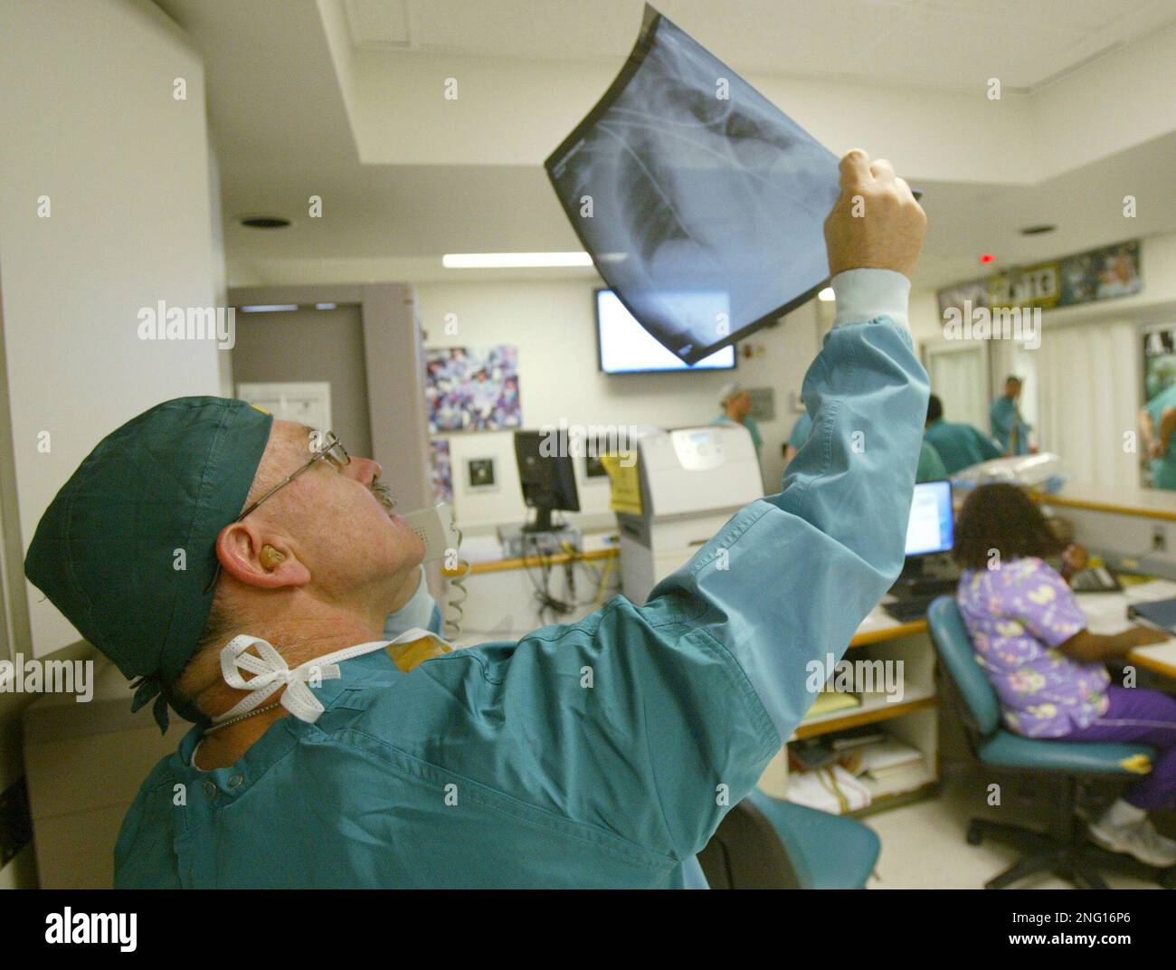 Col Michael Oddi looks at an X-ray of an accident victim as he and ...