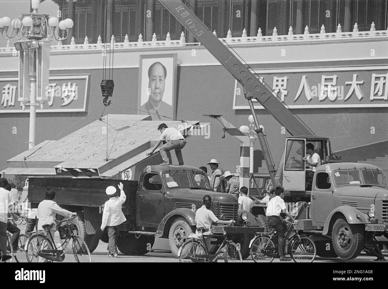 Chinese workmen dismantle a stop light and traffic island in front of ...