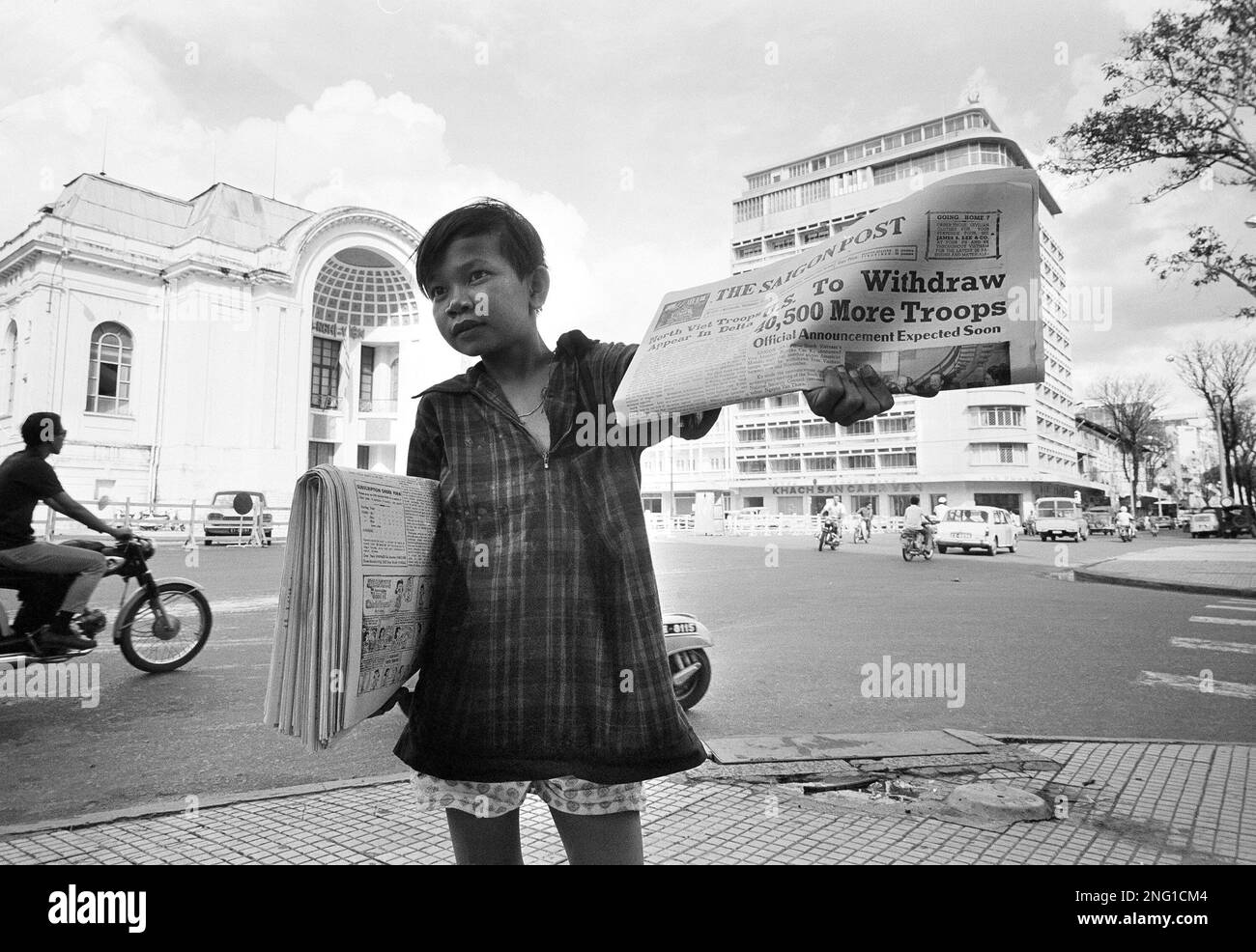 A Vietnamese newsboy sells newspapers in Saigon with the headline ...