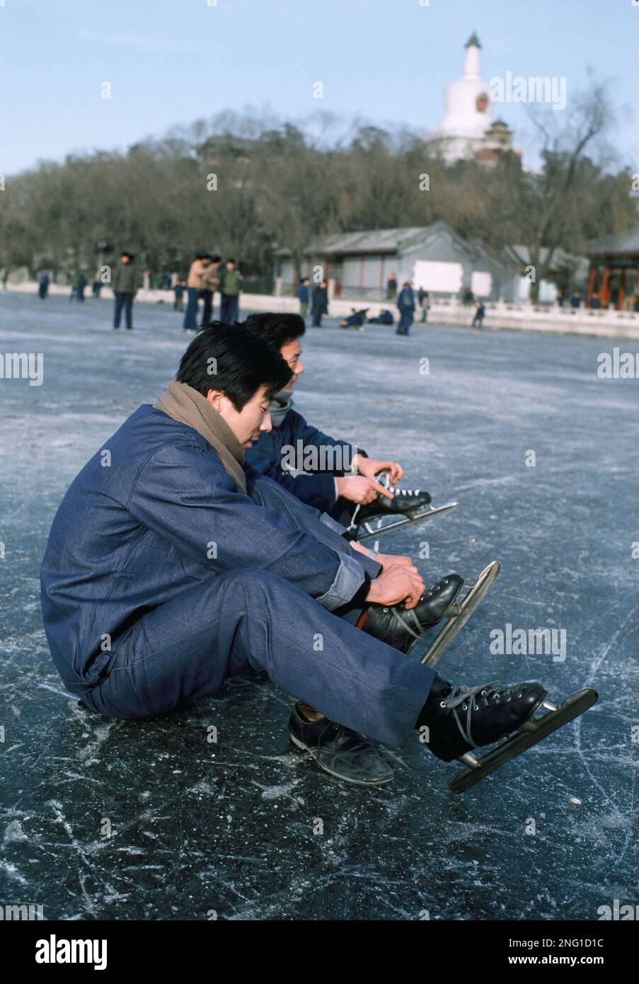 General scenes of people ice skating at Pei Hai Park, with pagoda in ...