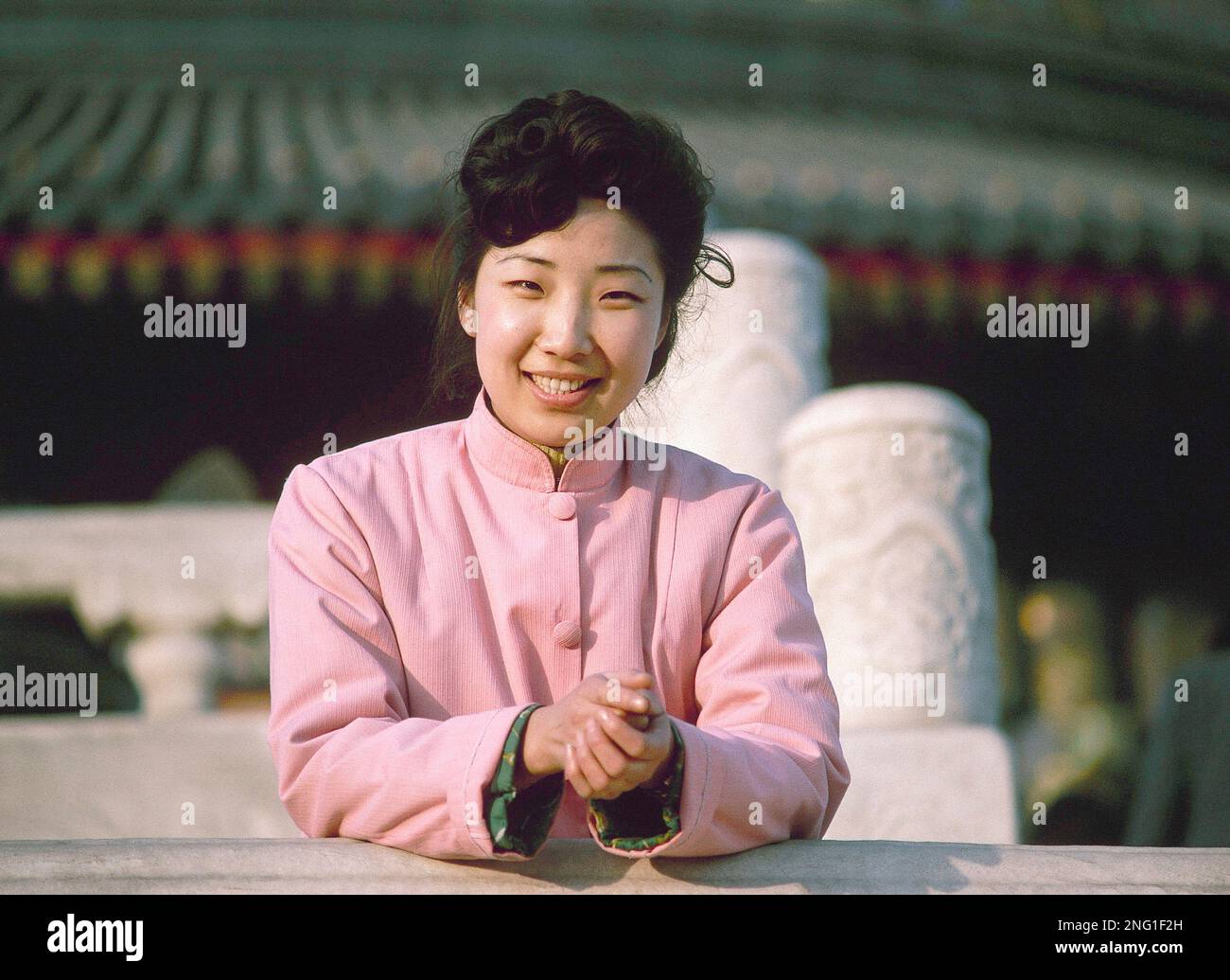 A woman poses at Beijing's Temple of Heaven at sunset, December 1, 1984 ...