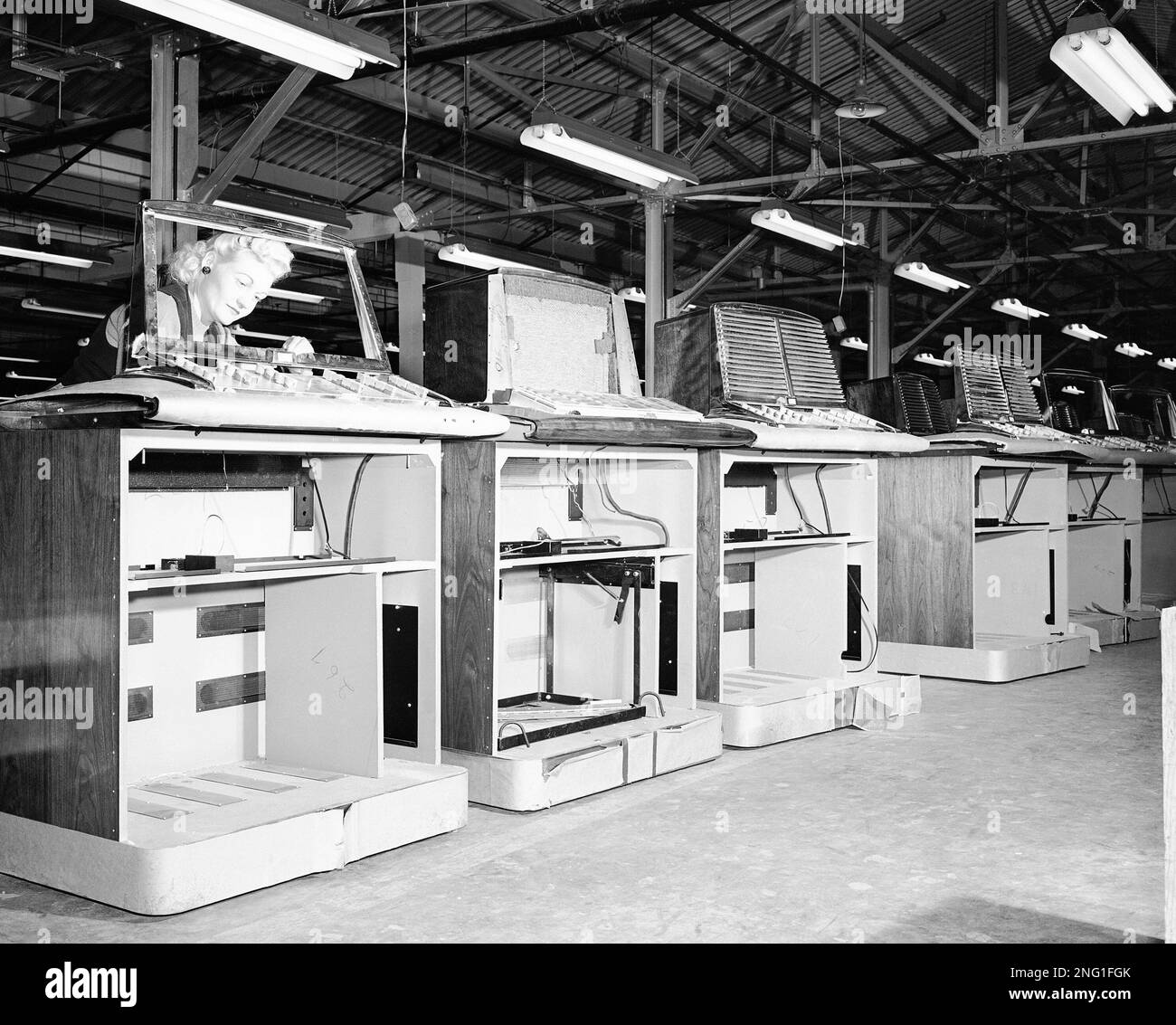 Betty Barnett, her face framed in a part of a jukebox, puts some final ...
